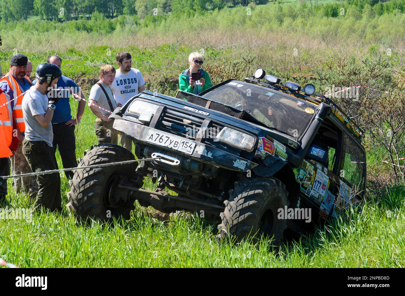 Crowd of spectators looking at the car "Suzuki Escudo" which is highly ...