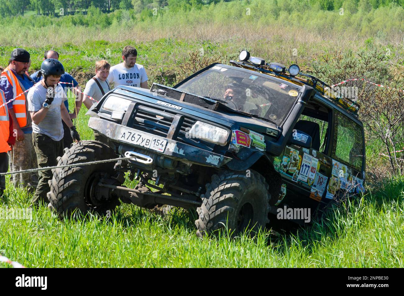 Crowd of spectators looking at the car "Suzuki Escudo" which is highly ...
