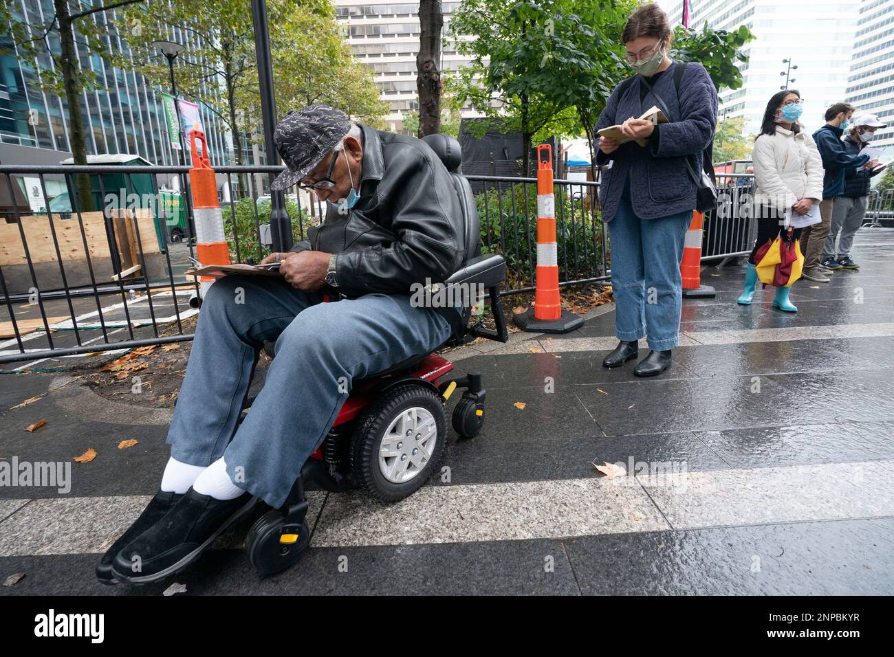 Joseph Wragg, front left, waits in line to vote at City Hall in ...