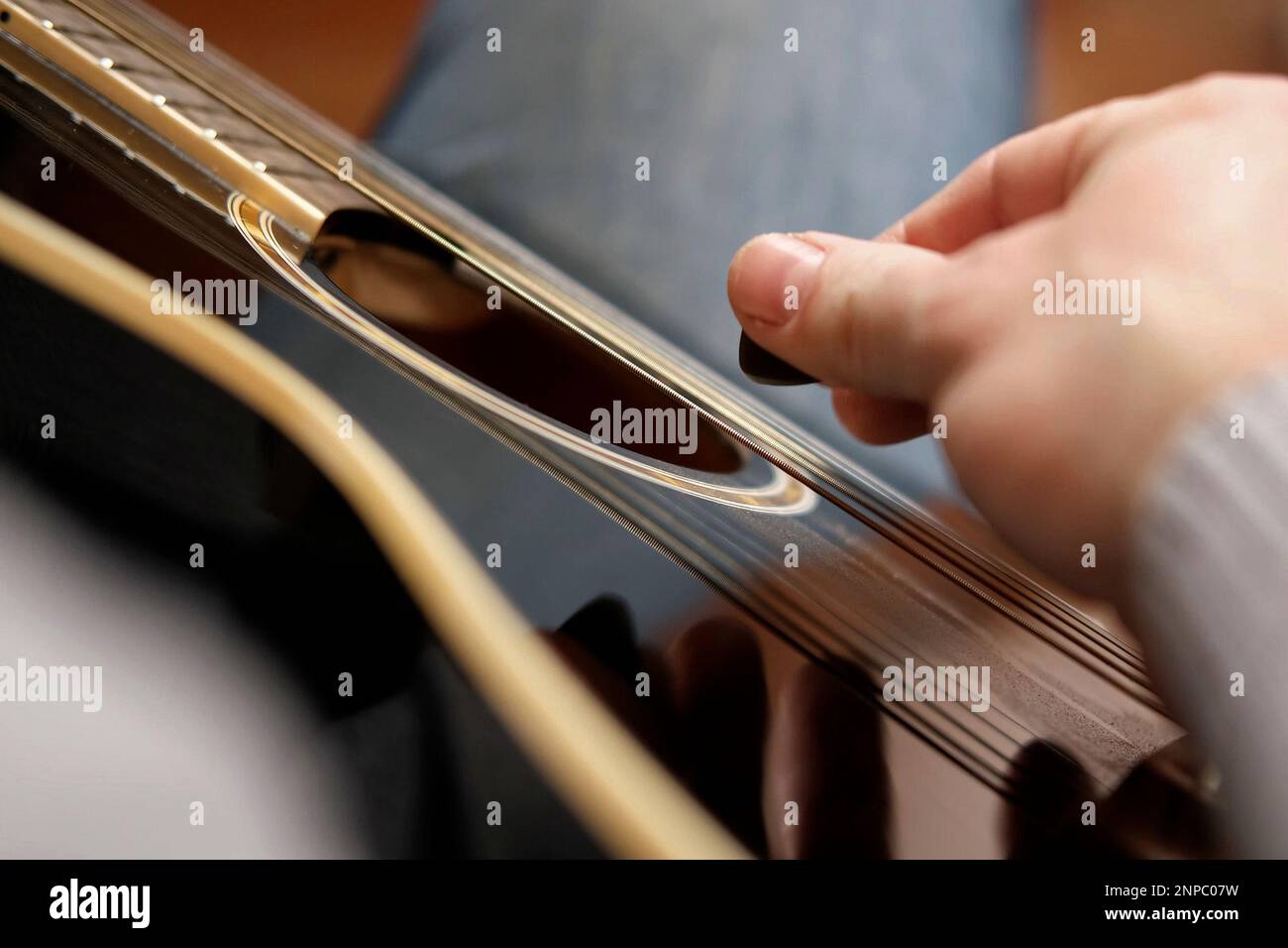 Playing the guitar. Strumming black acoustic guitar. Musician plays ...