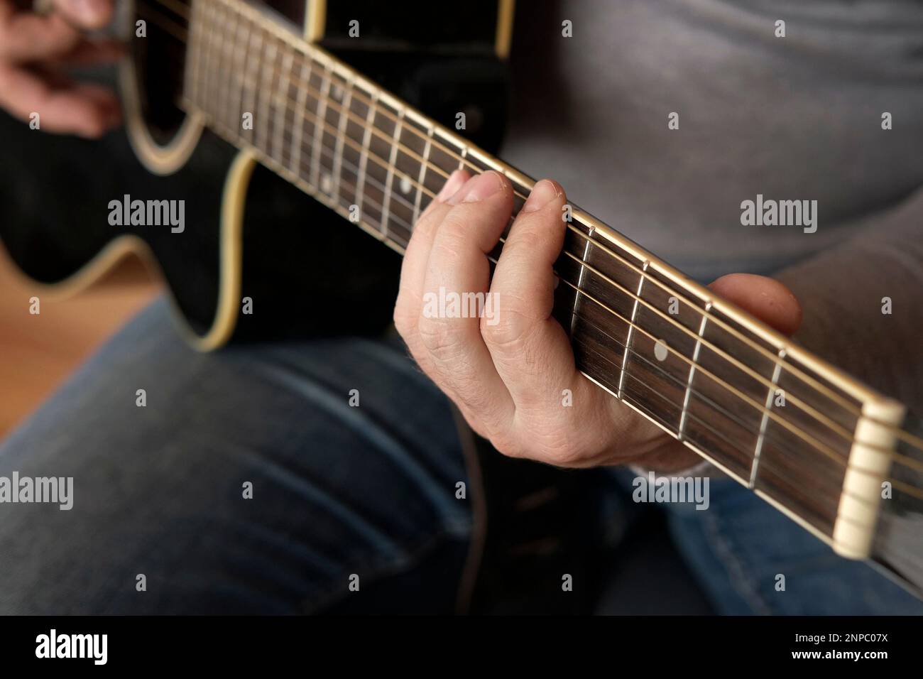 Playing the guitar. Strumming black acoustic guitar. Musician plays ...
