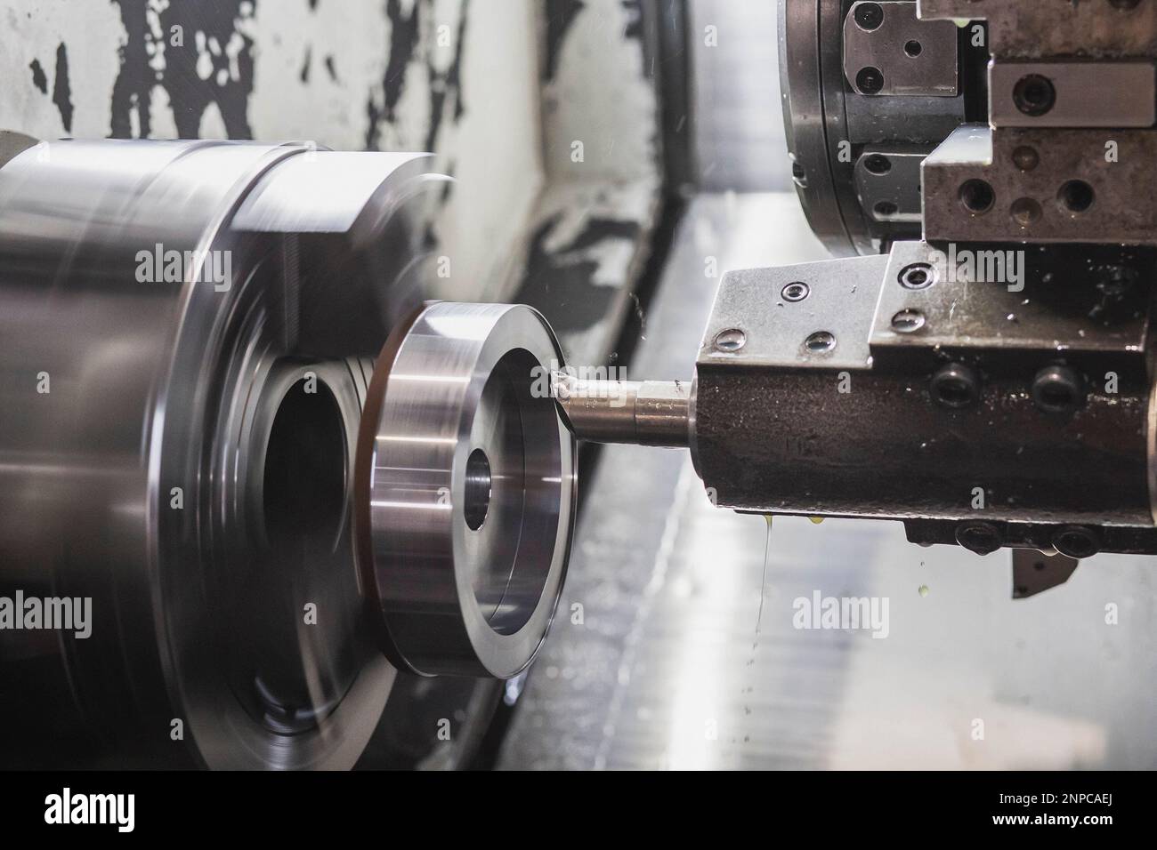A milling cutter in a CNC machine cuts a metal workpiece that rotates ...
