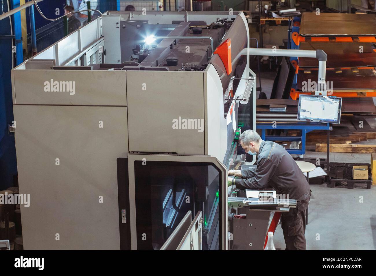 Worker holds a part in a CNC bending machine Stock Photo - Alamy