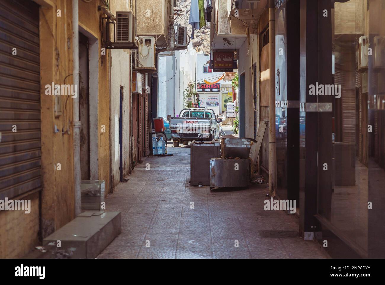 Old city, Egypt,March 2020: Dirty back alley with trash bins and a car ...