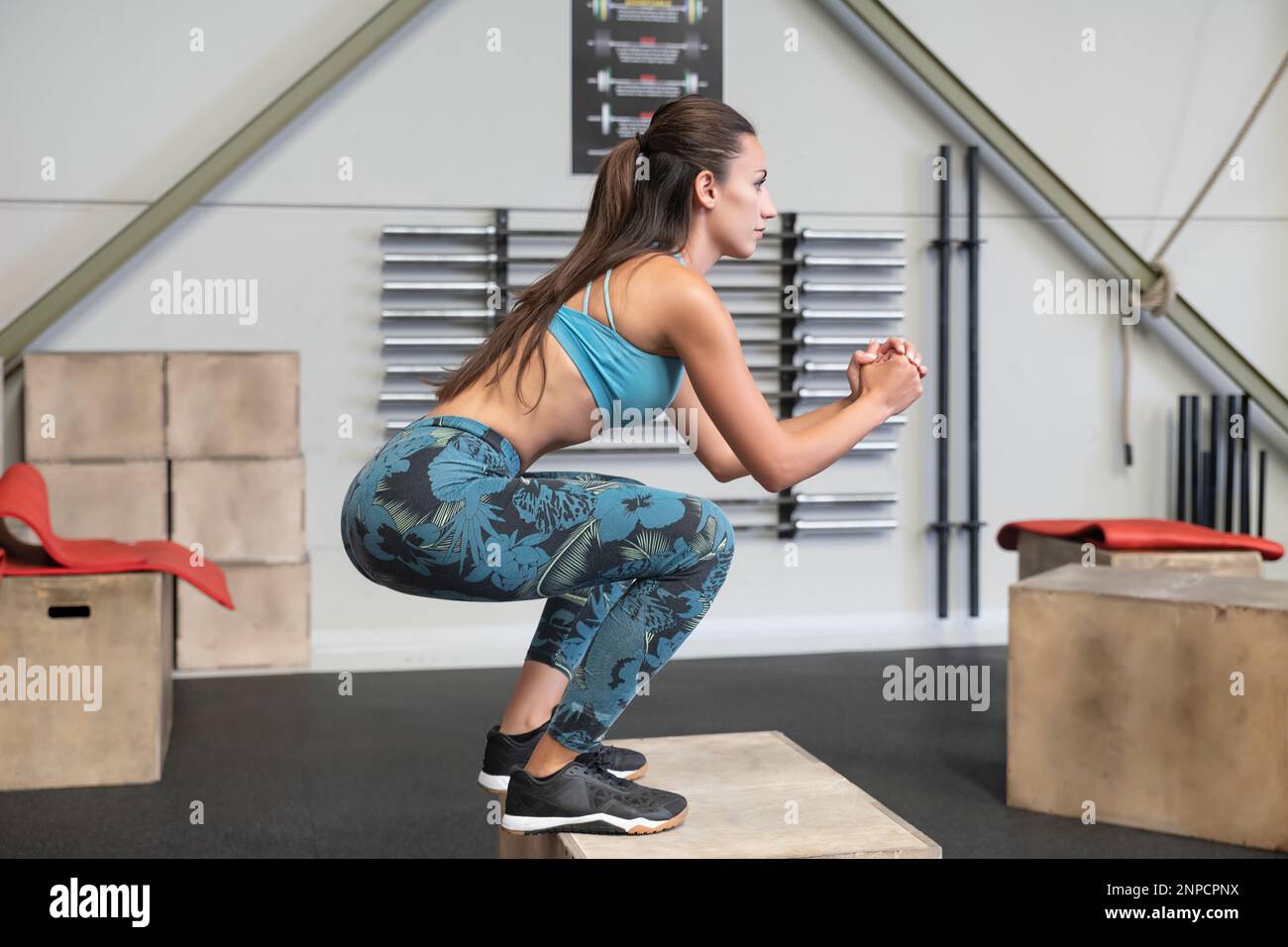 Fit millennial woman using wooden cubes as props in her fitness routine ...
