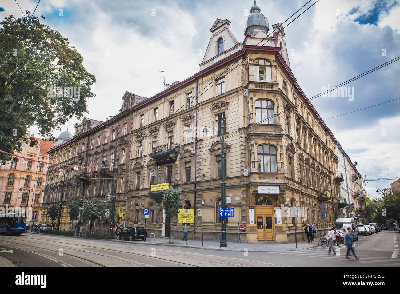 Beautiful corner house in Warsaw. Tourists walk the cobbled streets ...