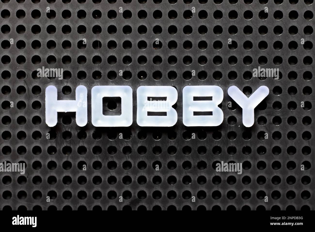 White color alphabet with word hobby on black pegboard background Stock ...