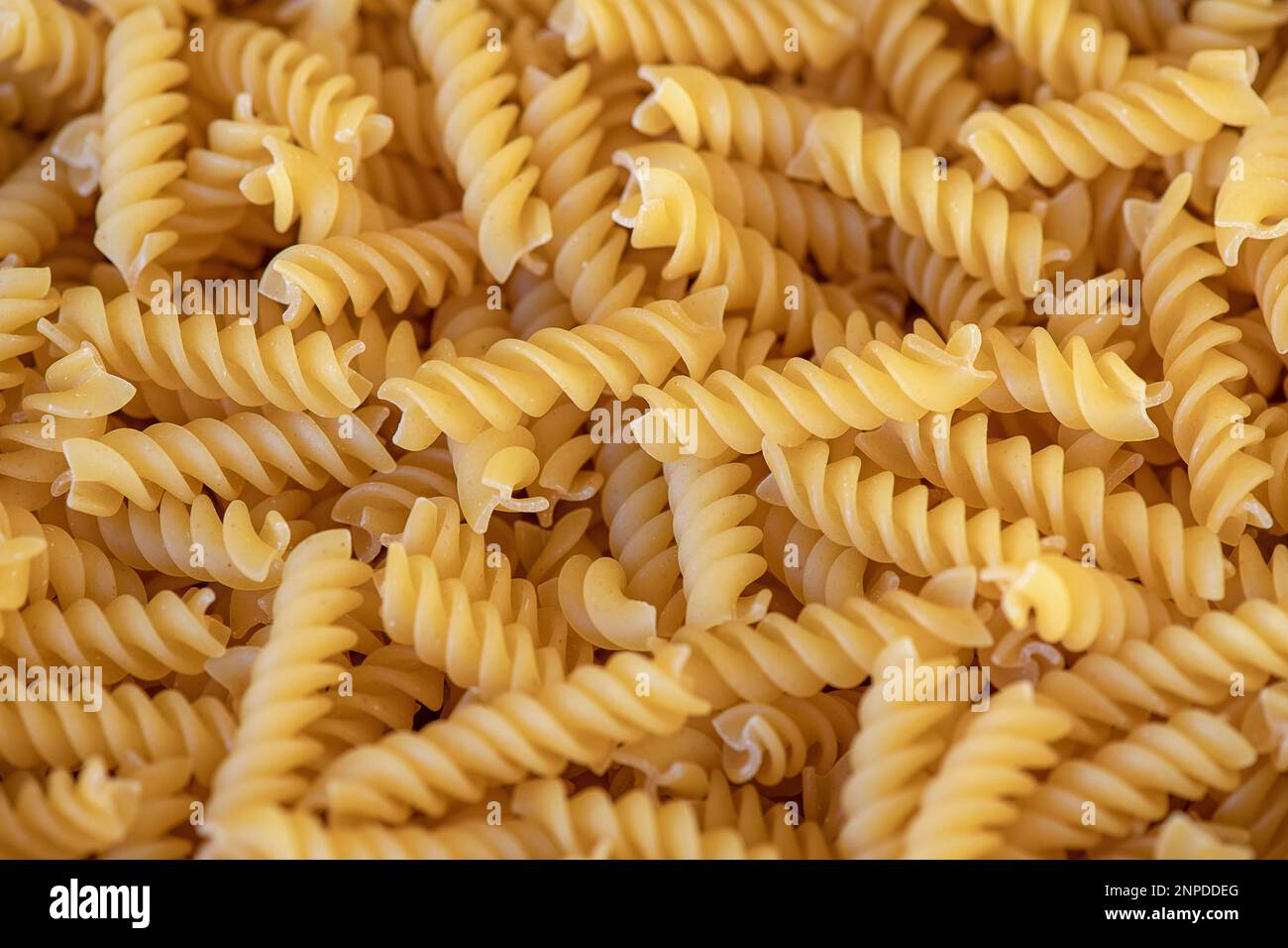 Golden fusilli dry pasta with its spiral shape and firm texture, a ...