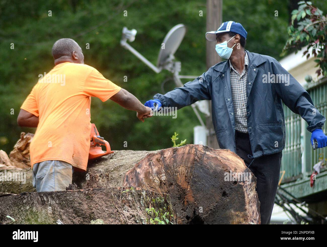 Carey Blackmon, left, and Jerry Veal fist bump as Larry arrives to help ...