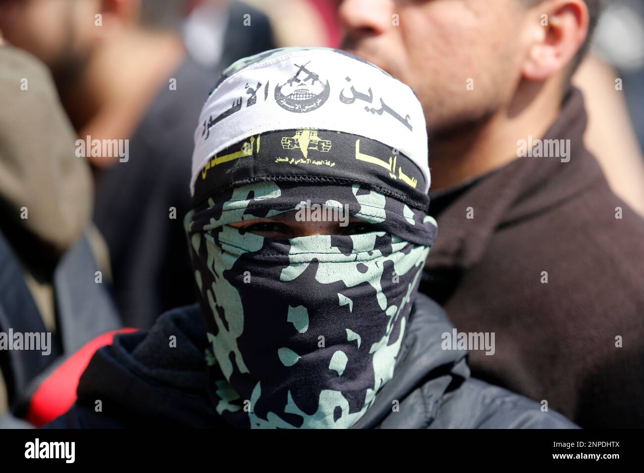 A masked Palestinian youth takes part during the demonstration against ...