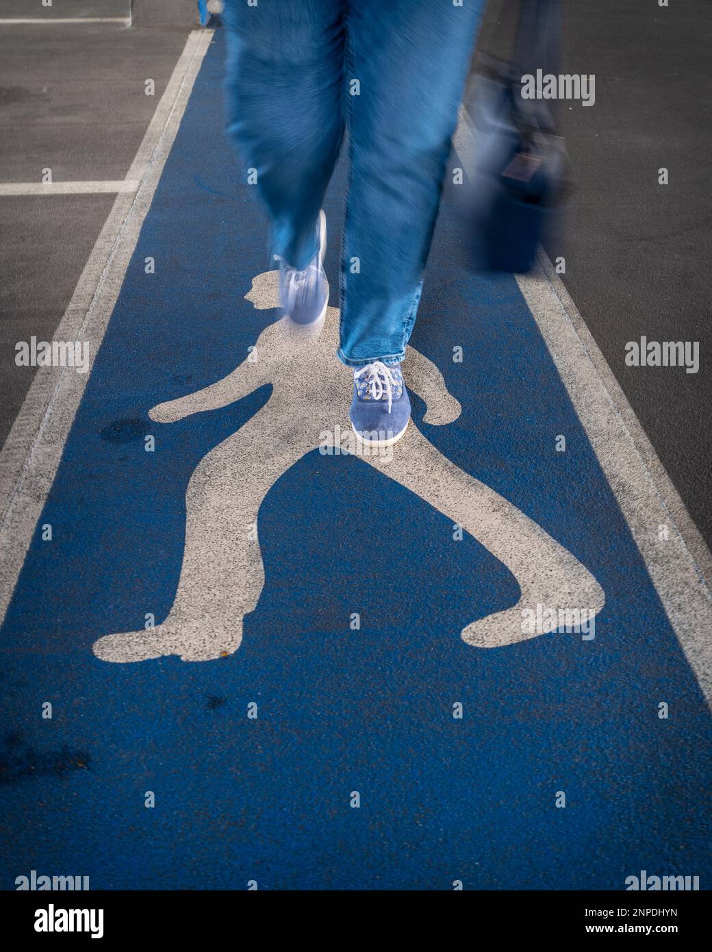 A woman walking along a pedestrian path in a multi story car park Stock ...