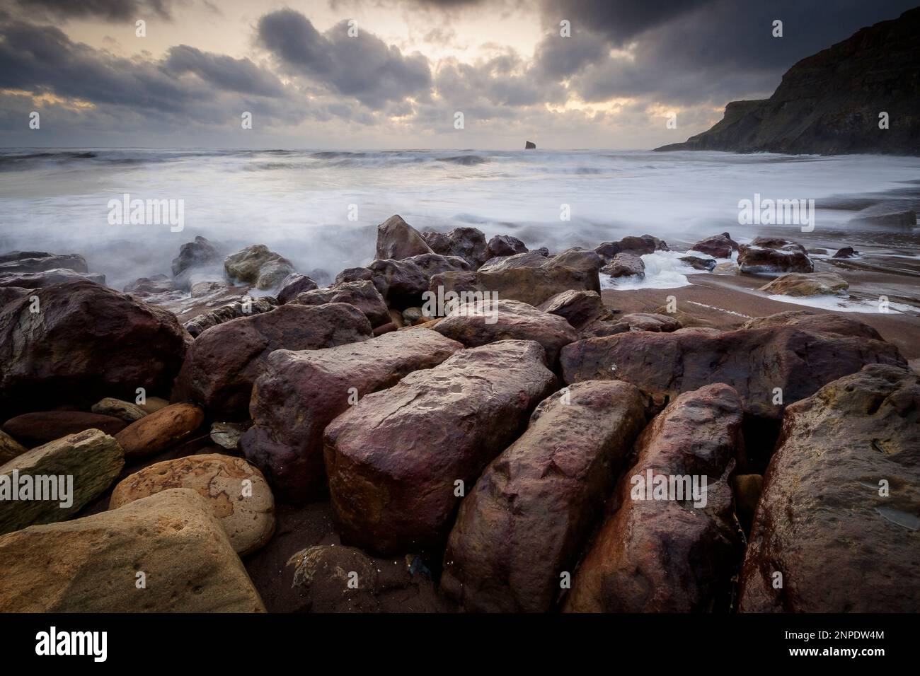 Saltwick Bay with the Black Nab on the horizon with rocks in the ...