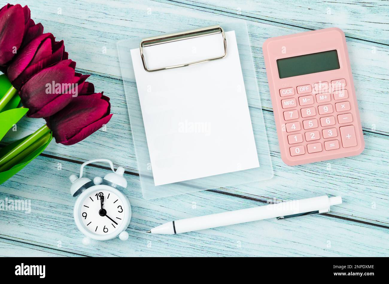 White paper blank page on clip board, calculator and alarm clock with ...