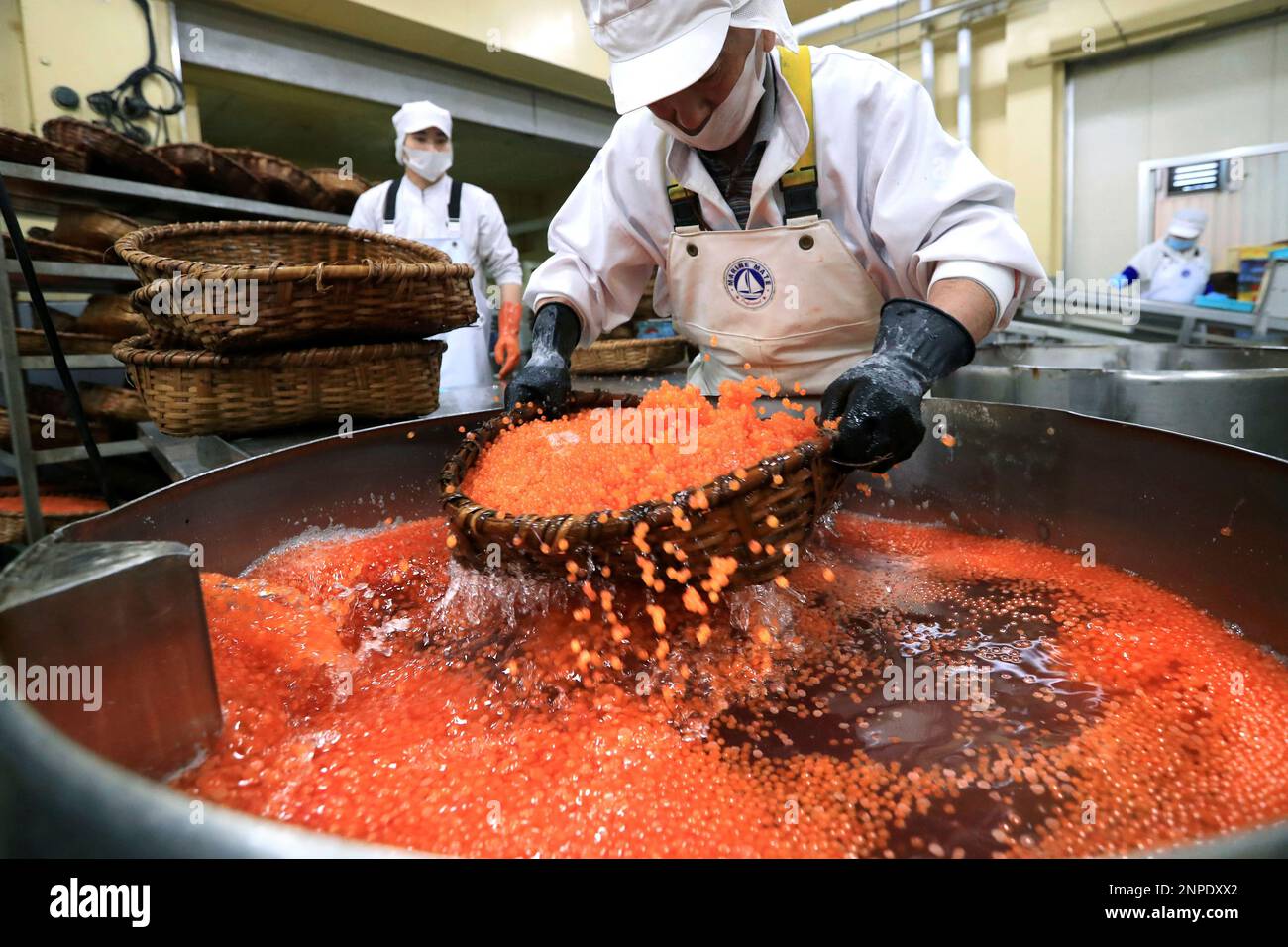 Workers rinse a salmon roe with salted water at Marua Abe shop after ...
