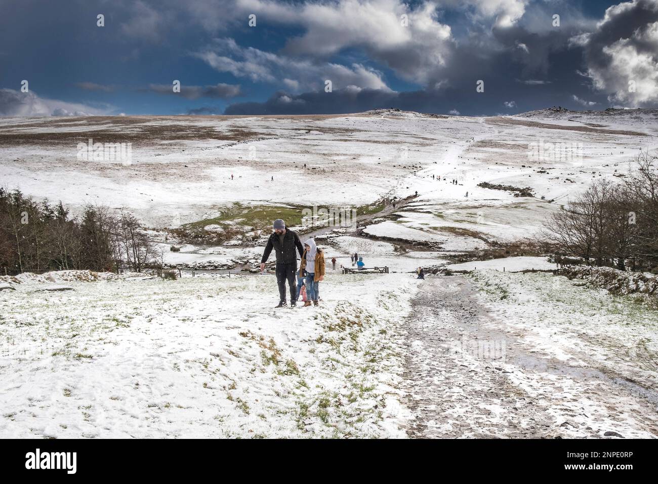 People enjoying walking in the snow on the wild rugged Rough Tor on ...