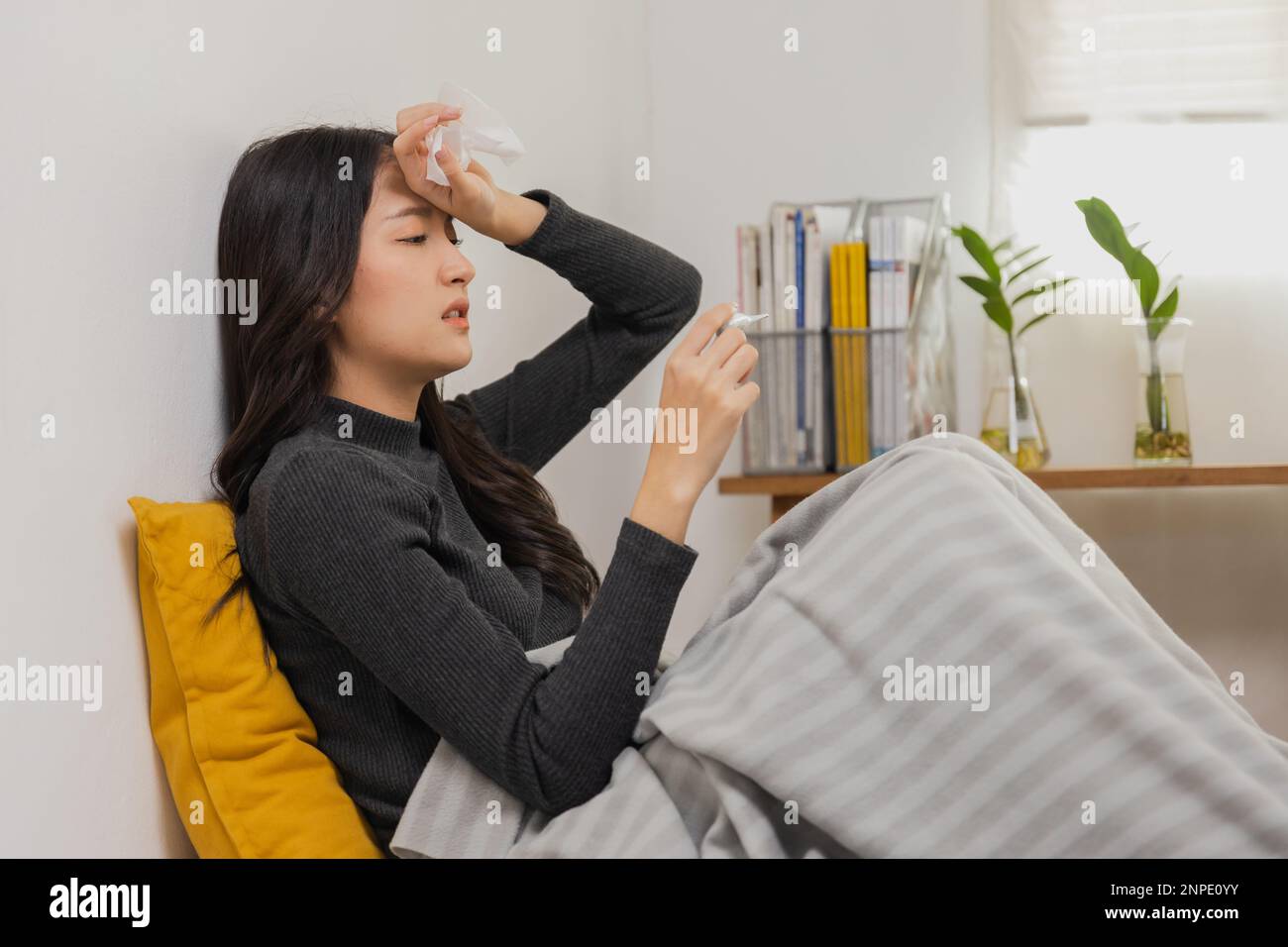 Asian female, young woman having cold, high temperature on bed Stock ...