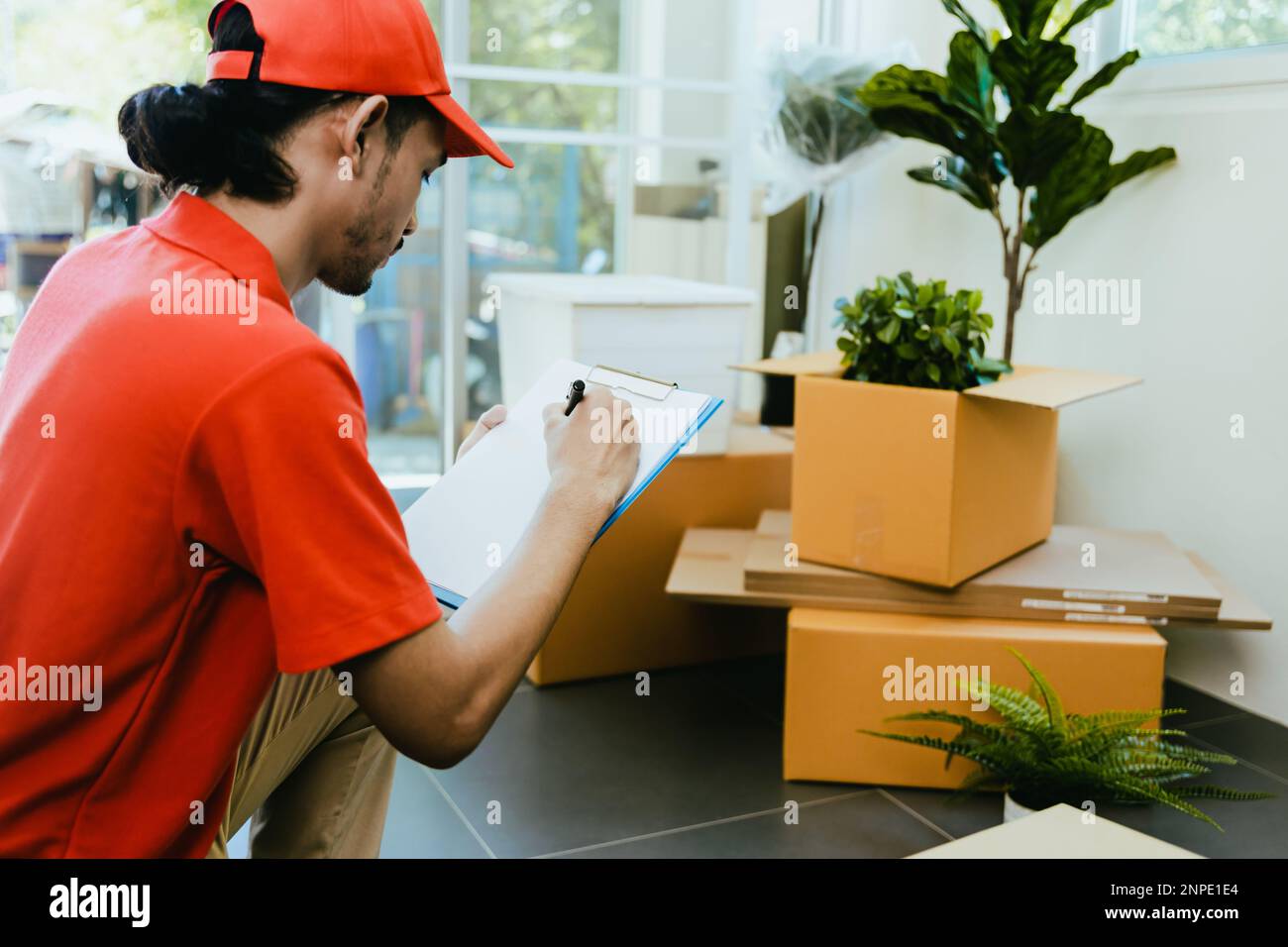 Delivery man checking delivery list before sent to customer Stock Photo ...