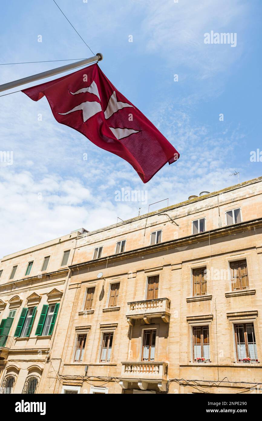 Maltese cross on a flag above a street in Valletta the capital city of ...