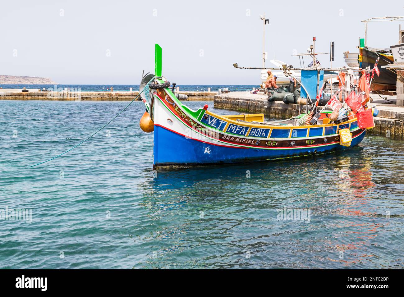 Luzzu boat at Mellieha harbour seen on the clear waters of the ...