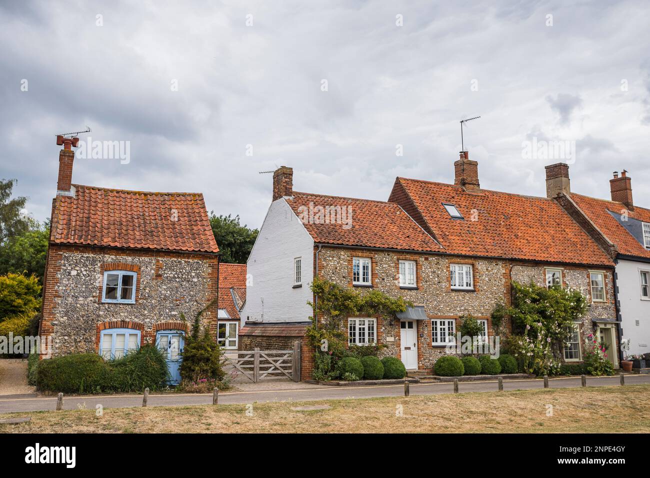 Traditional old cottages line the main road in the pretty Norfolk ...