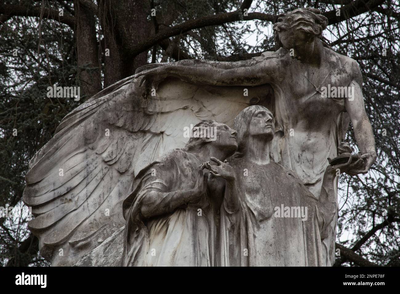 Angel protecting two people beneath its wing Monumental Cemetery of ...