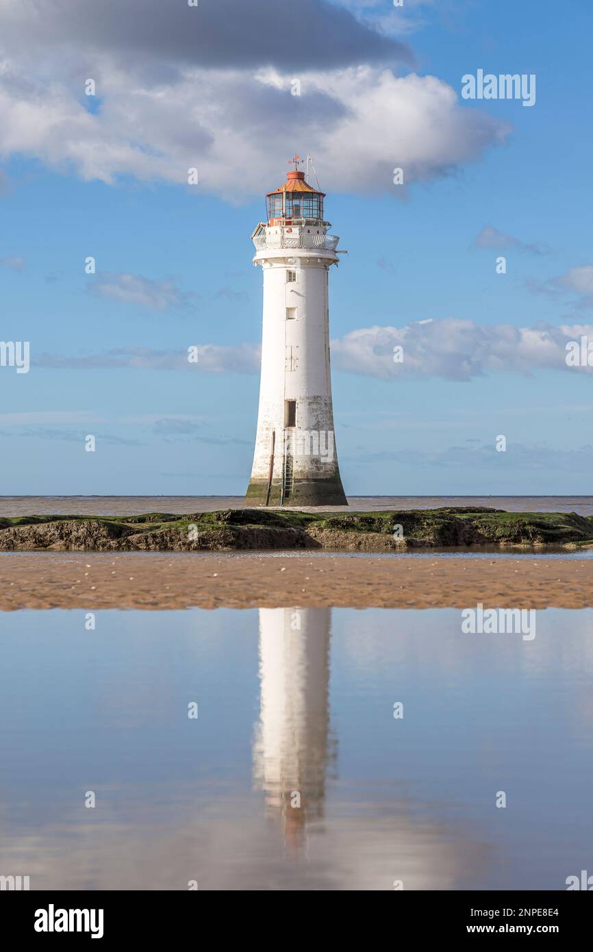 New Brighton Lighthouse reflects in a pool of water as the tide goes ...