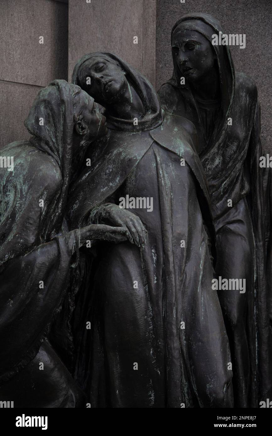 Two figures supporting a grieving woman, in the Monumental Cemetery of ...