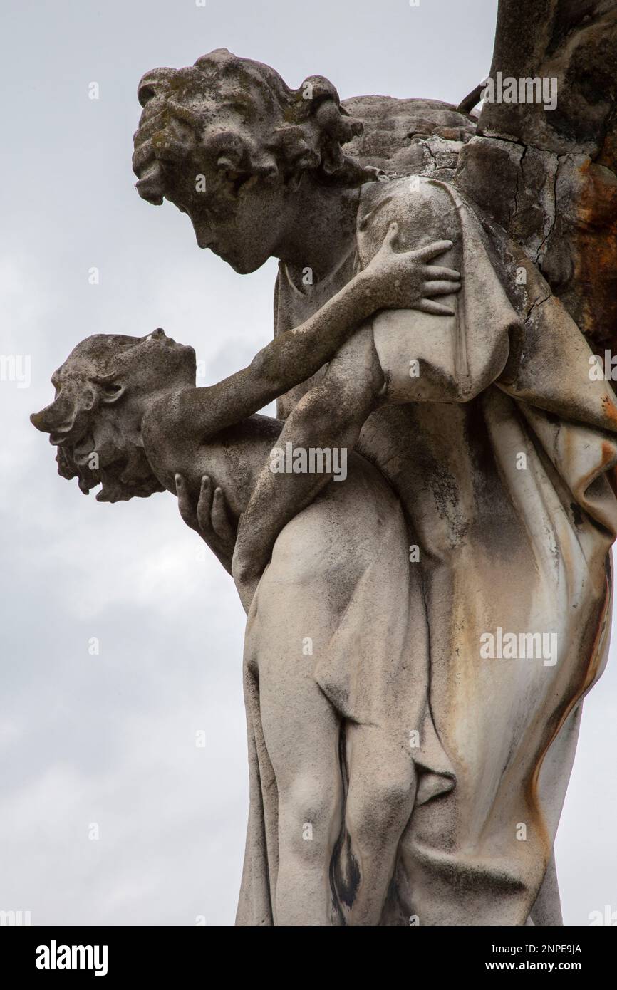 Angel holding a child, funerary sculpture in the Monumental Cemetery of ...