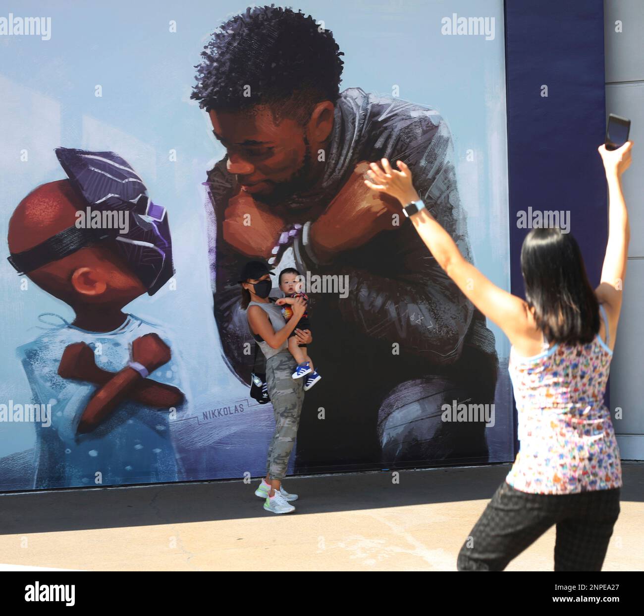 September 29, 2020, Anaheim, California, USA: People make their way pass the Chadwick Boseman ...