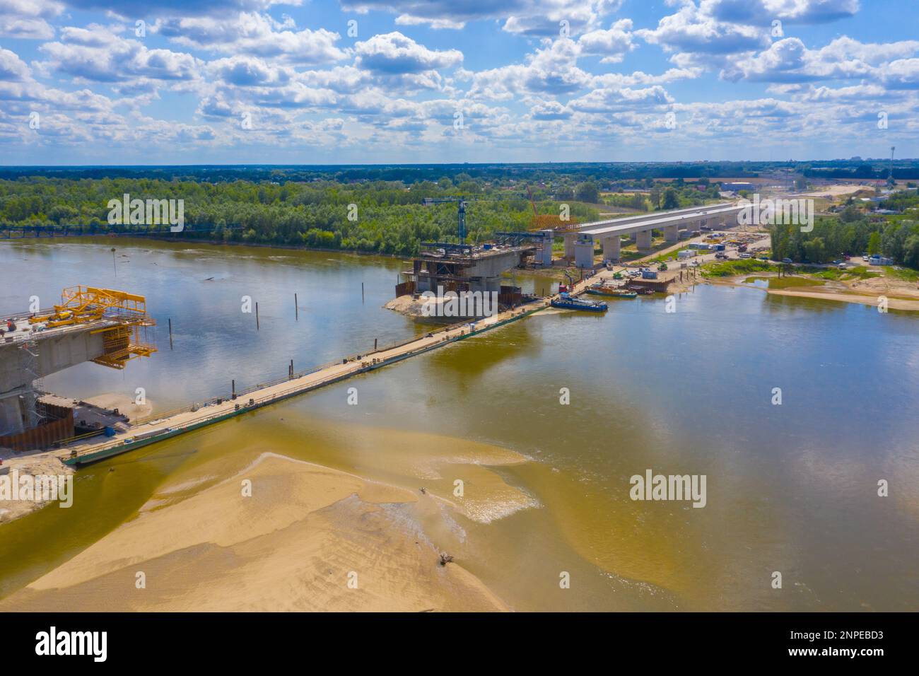 Aerial shot passing over a bridge construction project at sunset in ...