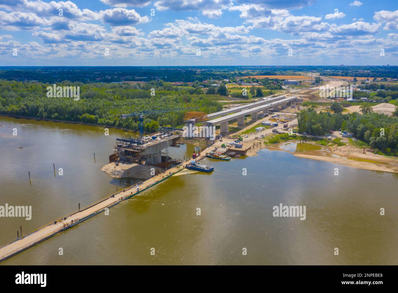 Aerial shot passing over a bridge construction project at sunset in ...
