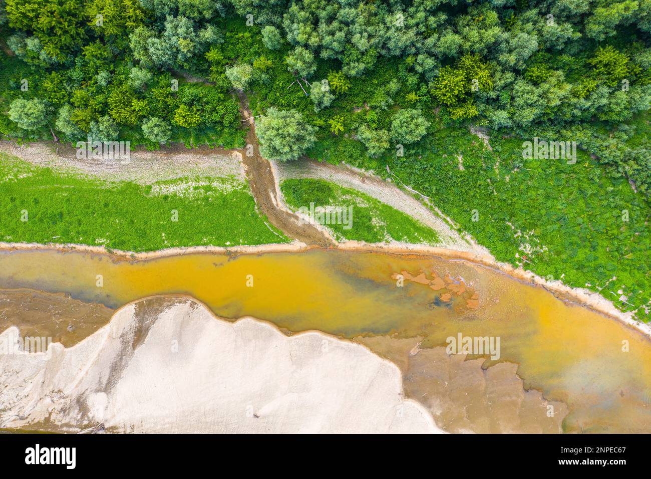 Top down view on exotic winding river flows through green wetlands. Birds eye view of zig-zag ...