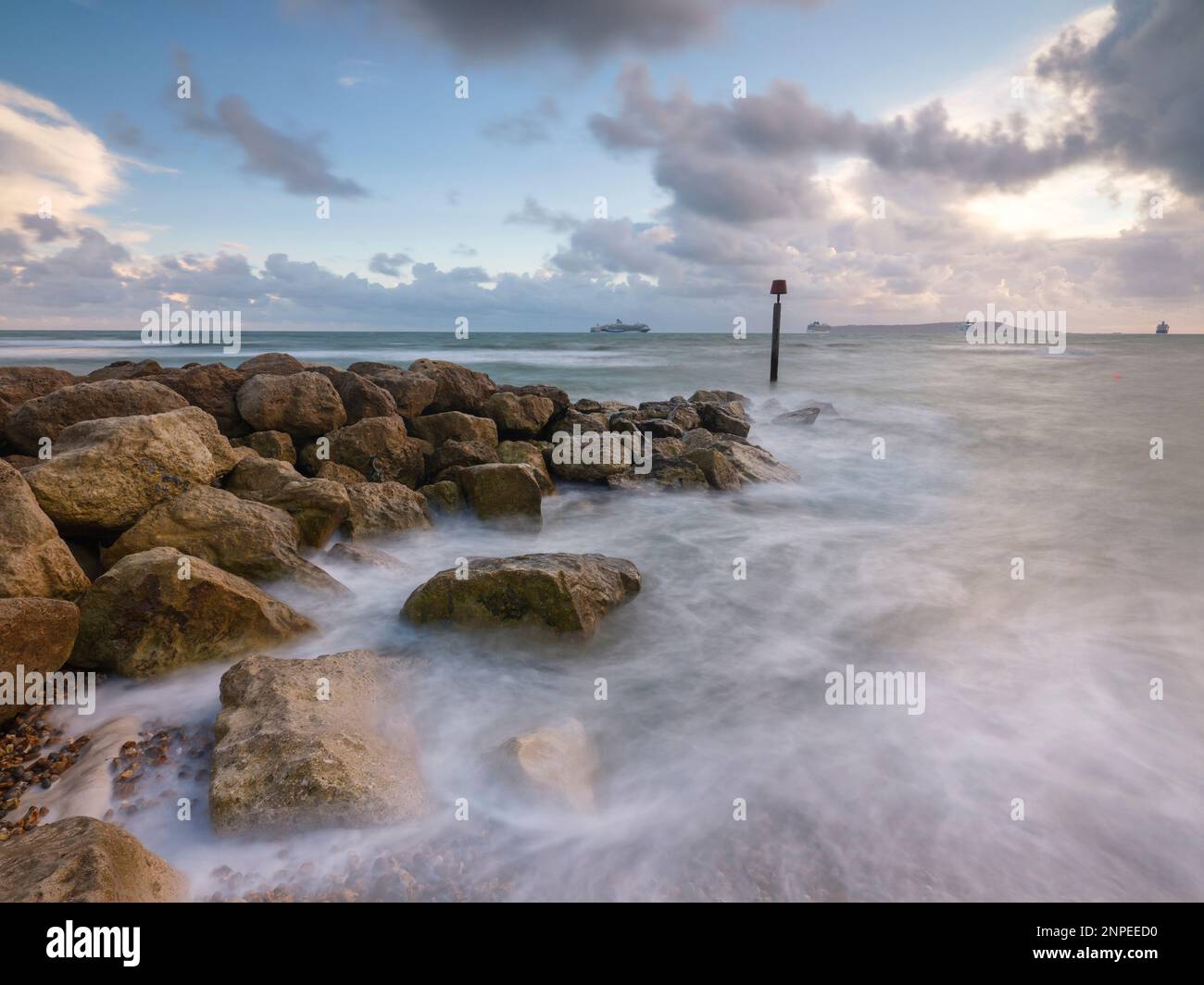 Waves washing around a stone groyne on a Dorset beach Stock Photo - Alamy