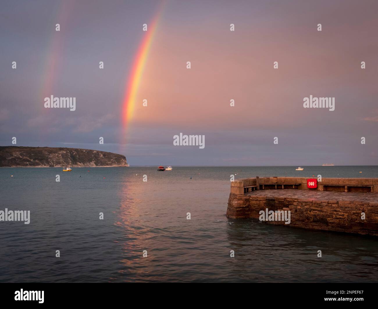 A rainbow over Swanage Bay with the Old Stone Quay in the foreground ...