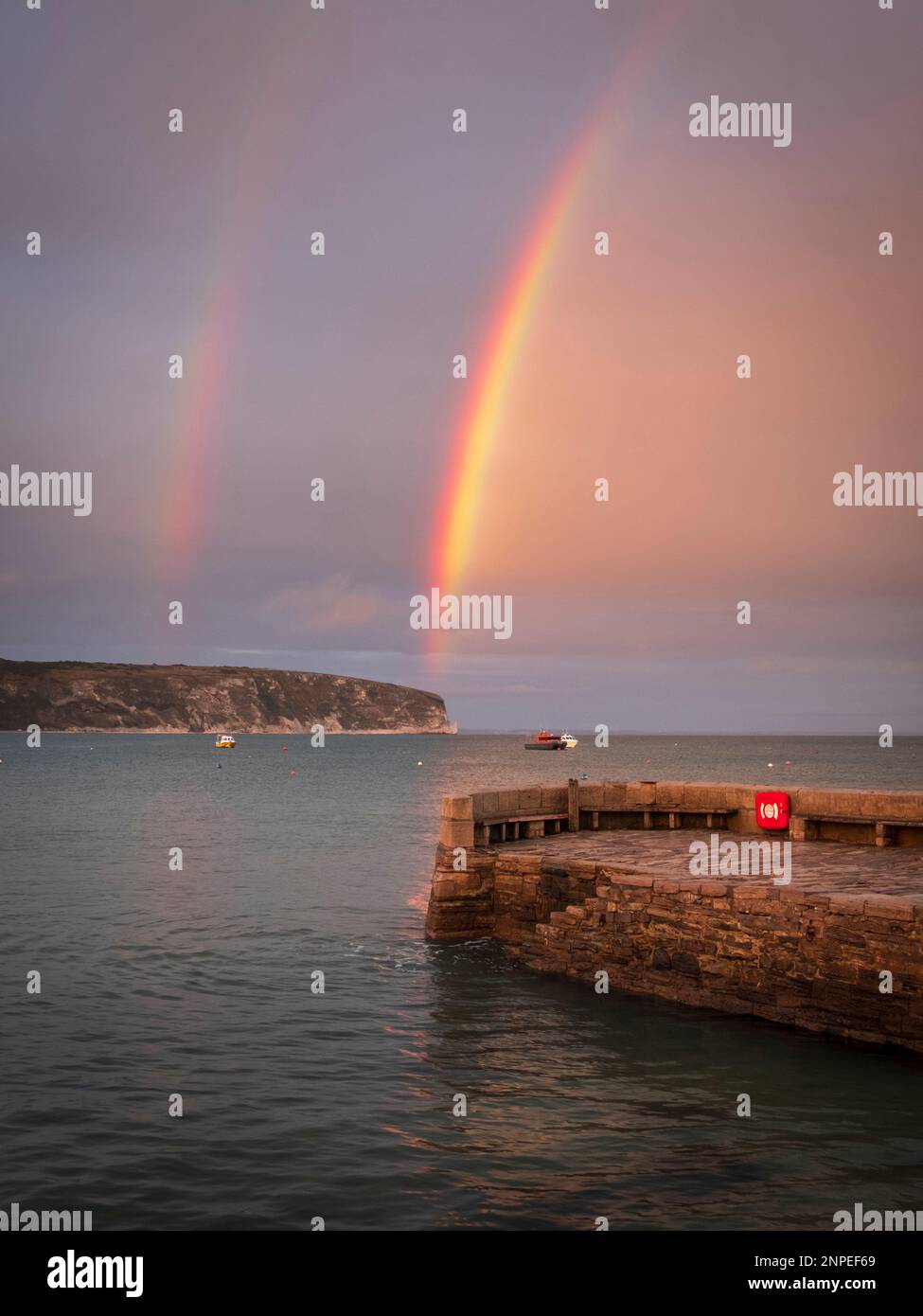 A rainbow over Swanage Bay with the Old Stone Quay in the foreground ...