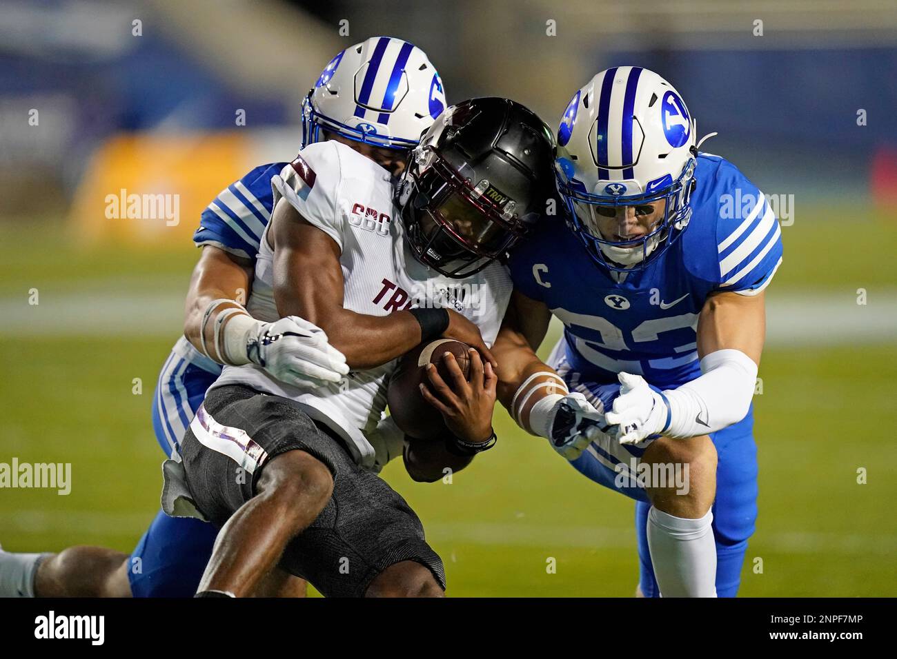 Troy wide receiver Kaylon Geiger, center, is tackled by BYU linebacker ...