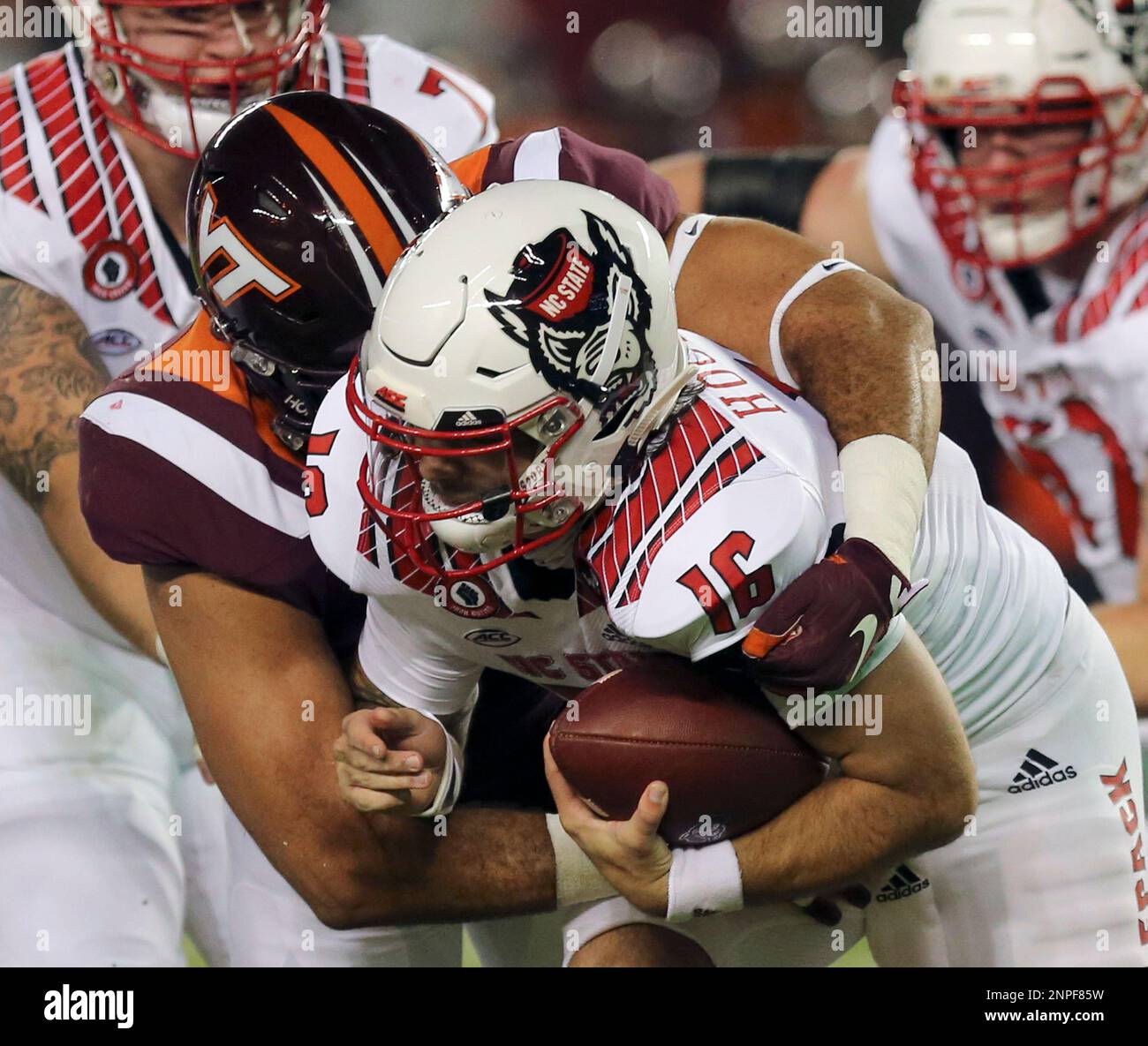 North Carolina State's Bailey Hockman, front, is sacked by Virginia ...