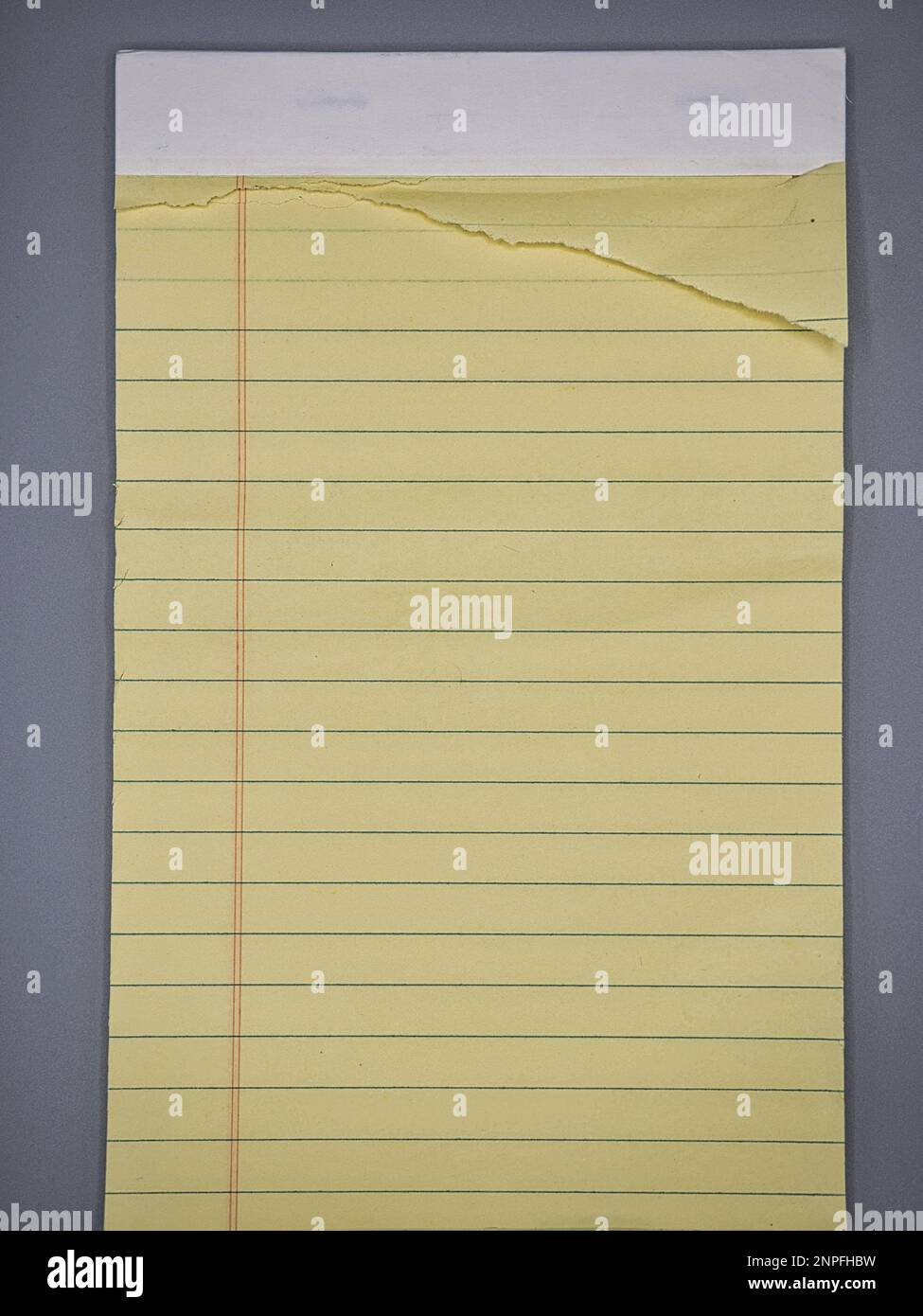 Yellow legal notepad on a plain gray background. Simple design to ...