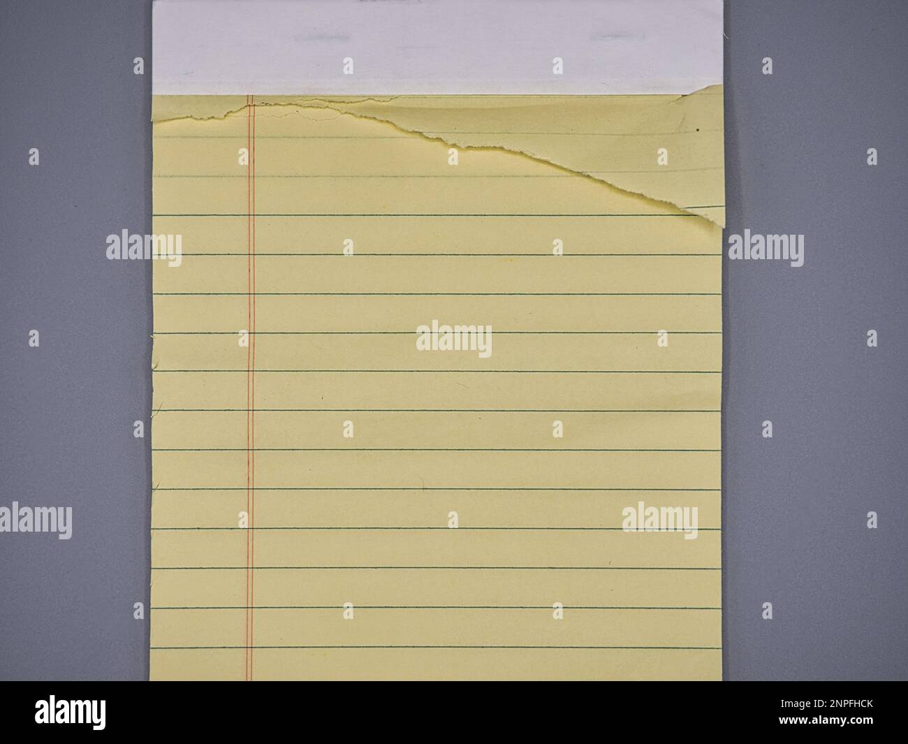 Yellow legal notepad on a plain gray background. Simple design to ...