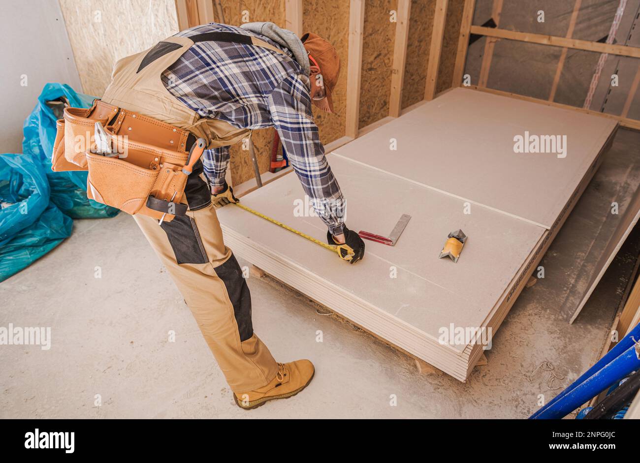General Construction Worker in His 40s Measuring Drywall Boards. New ...