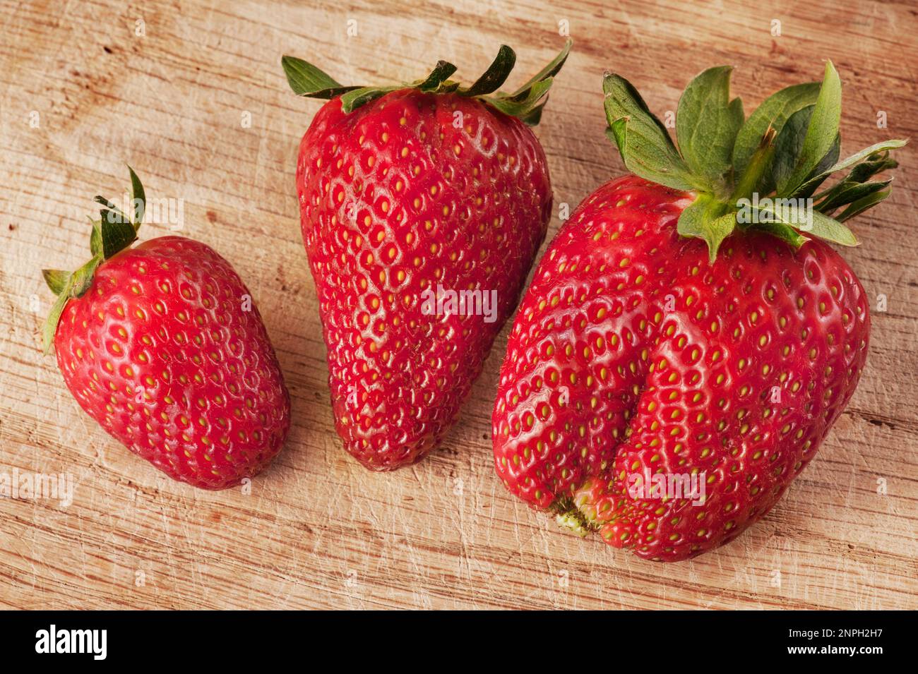 Three strawberries of different shapes Stock Photo - Alamy