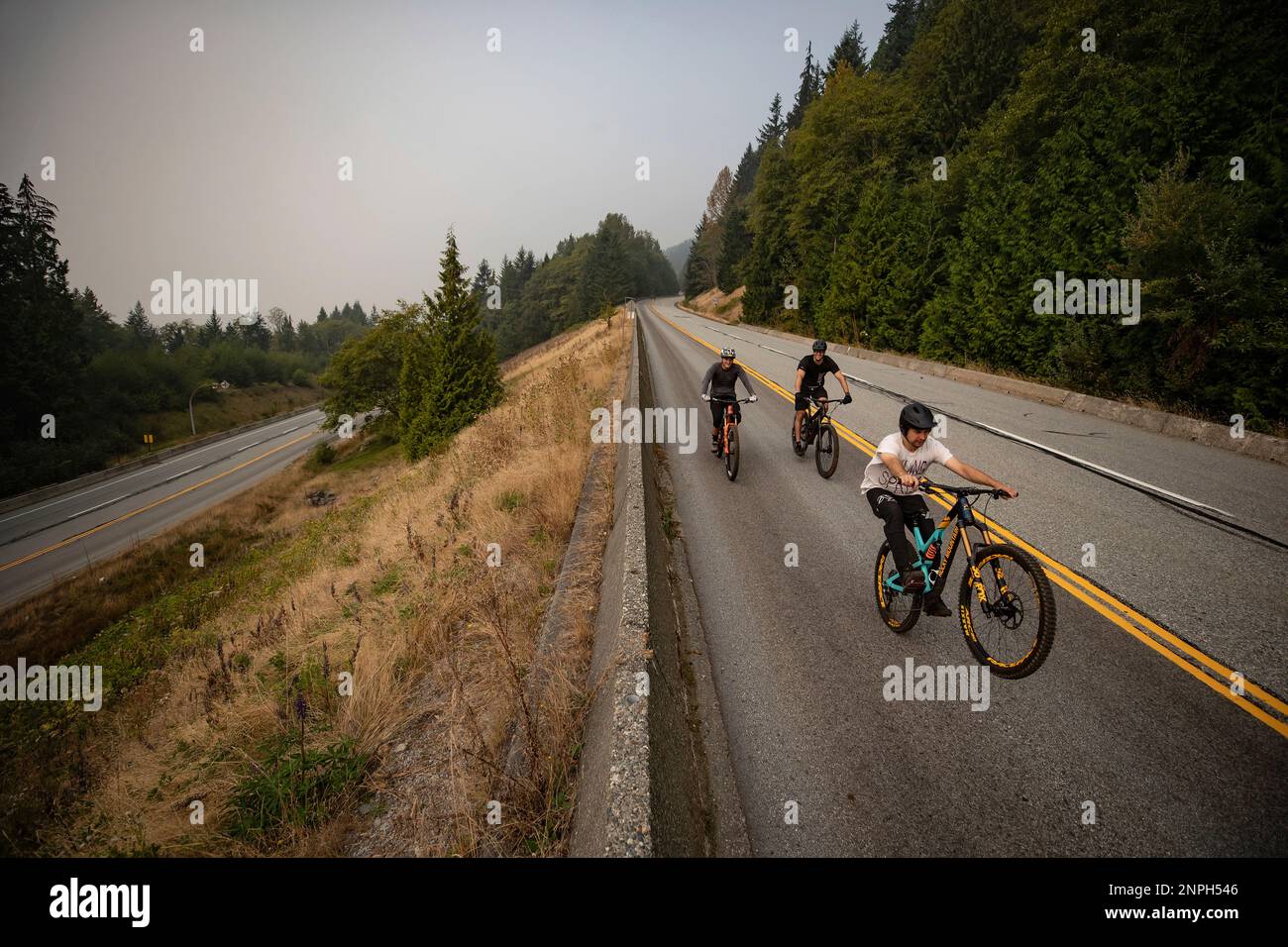 Smoke from wildfires burning in the U.S. fills the air as people ride ...