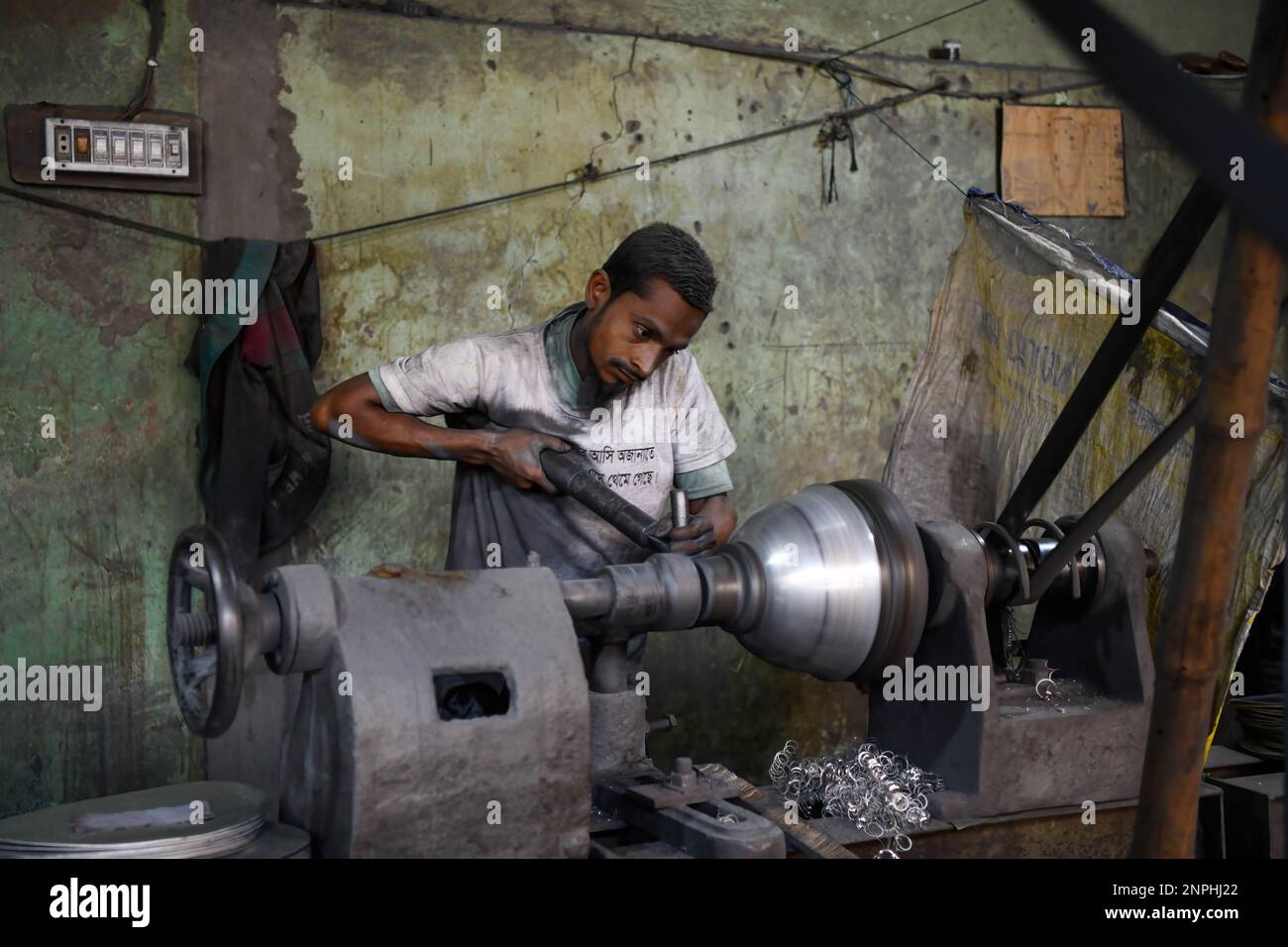 Bangladeshi laborer works at an aluminum pot factory in Dhaka. Aluminum ...