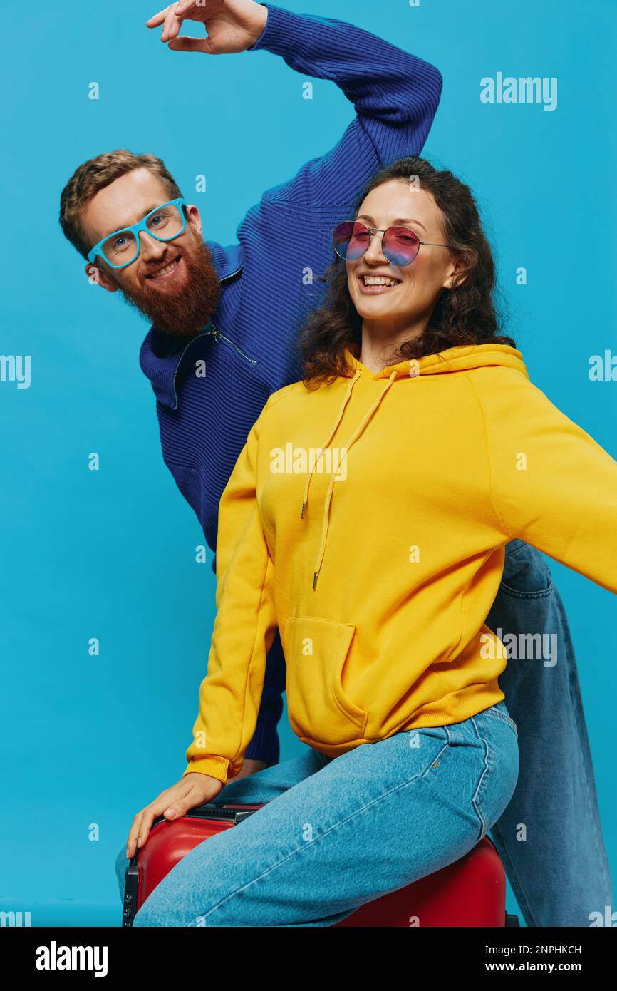Woman and man smile sitting on suitcase with red suitcase smile, on ...
