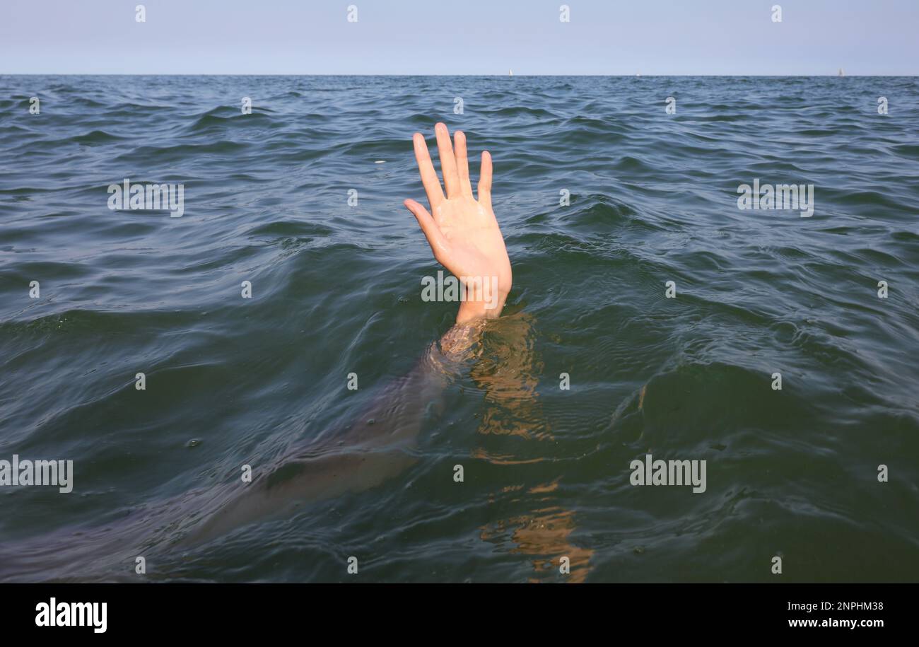 human hand of the person about to drown in the middle of the sea after ...