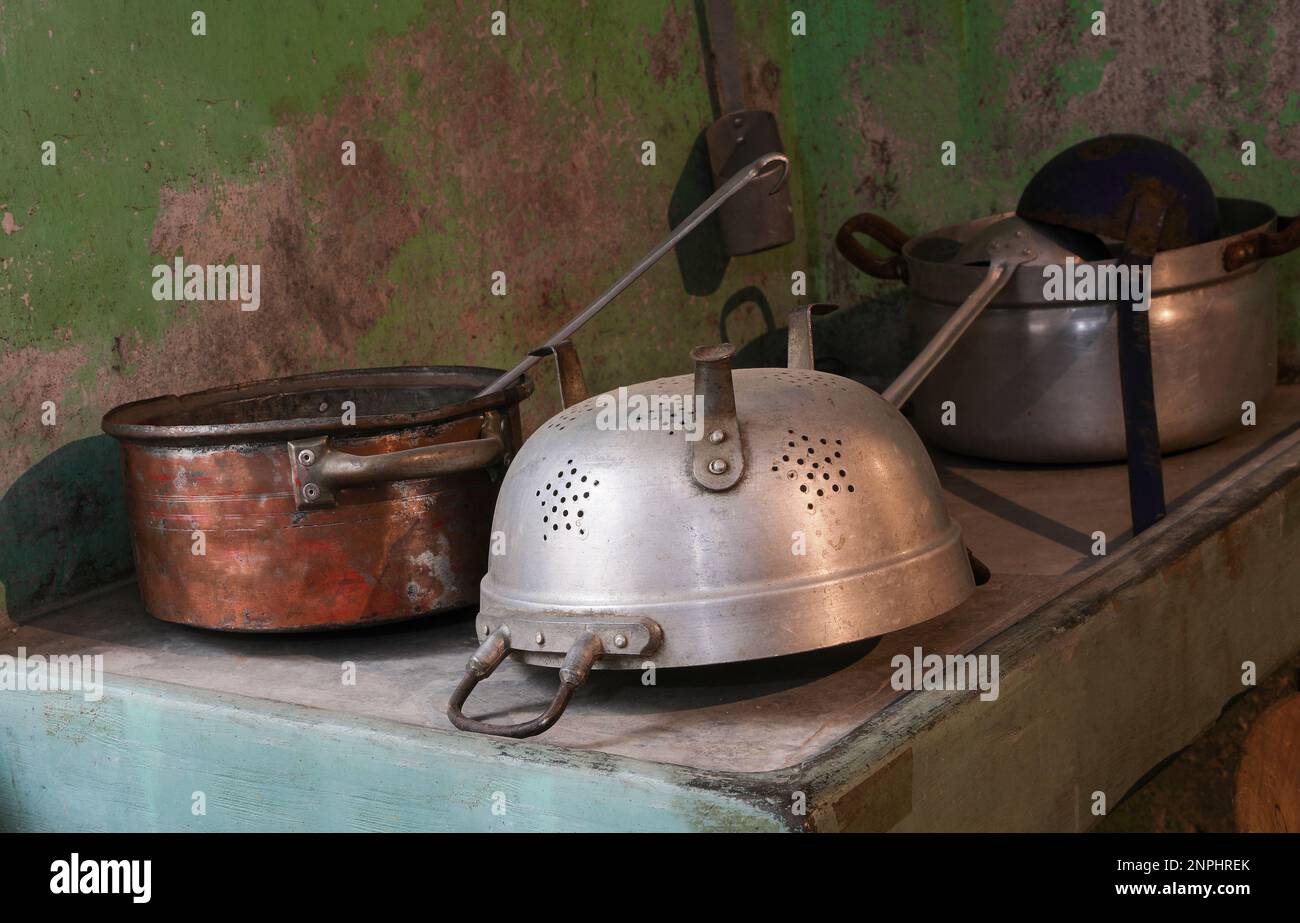 old copper cookware cauldron and colander over a bucket of the rural ...