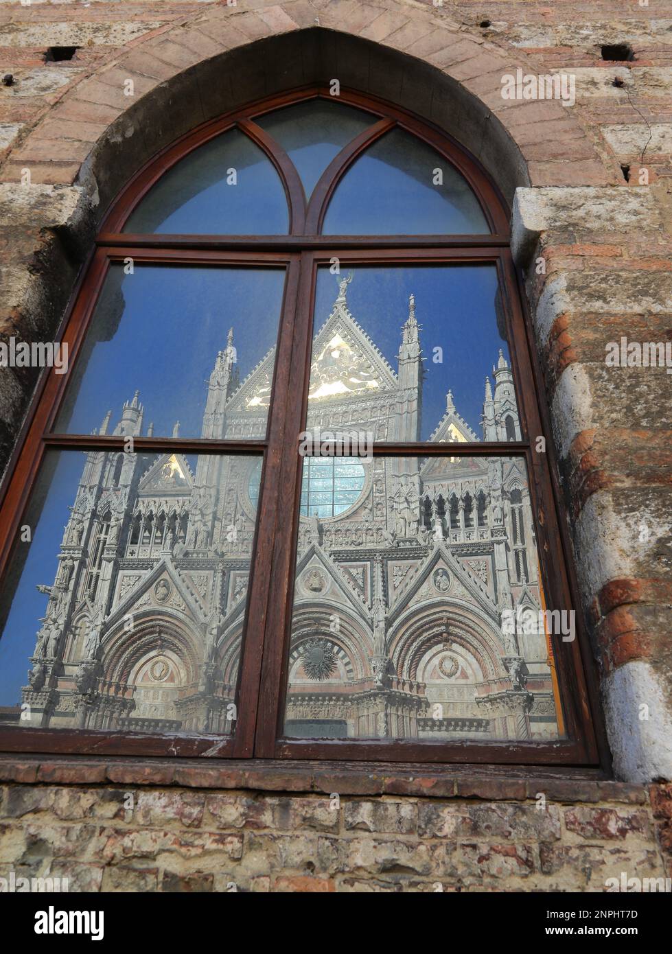 reflection on ancient window of the facade of Siena Cathedral in Italy ...