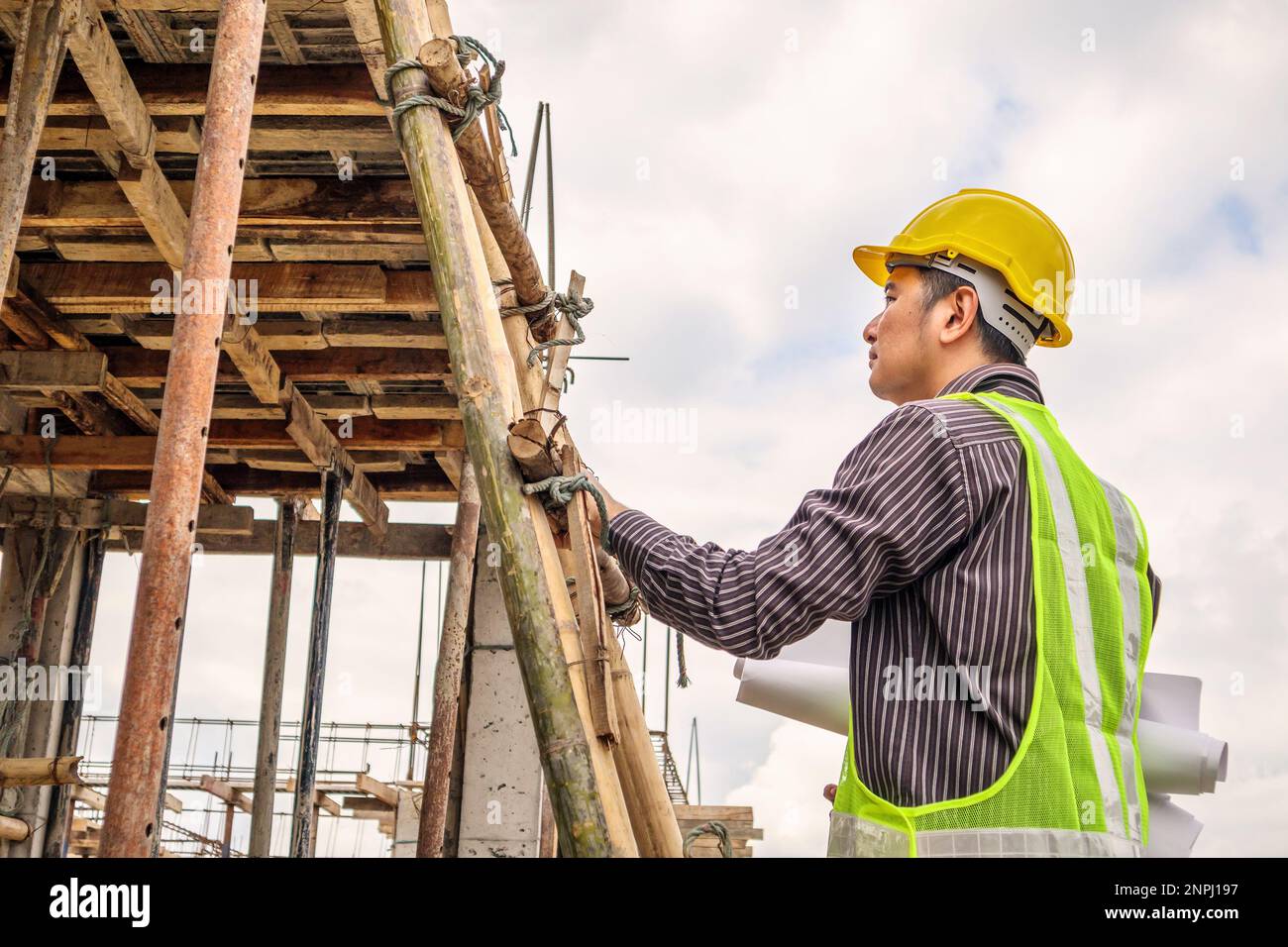 young professional engineer worker in protective helmet and blueprints ...