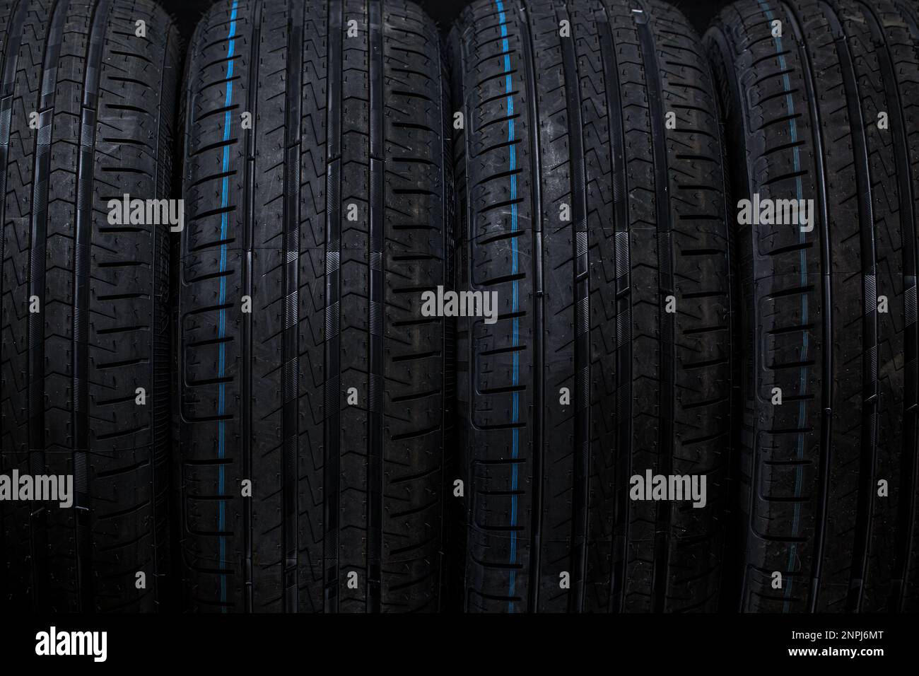 Stack of brand new high performance car tires on clean high-key white ...