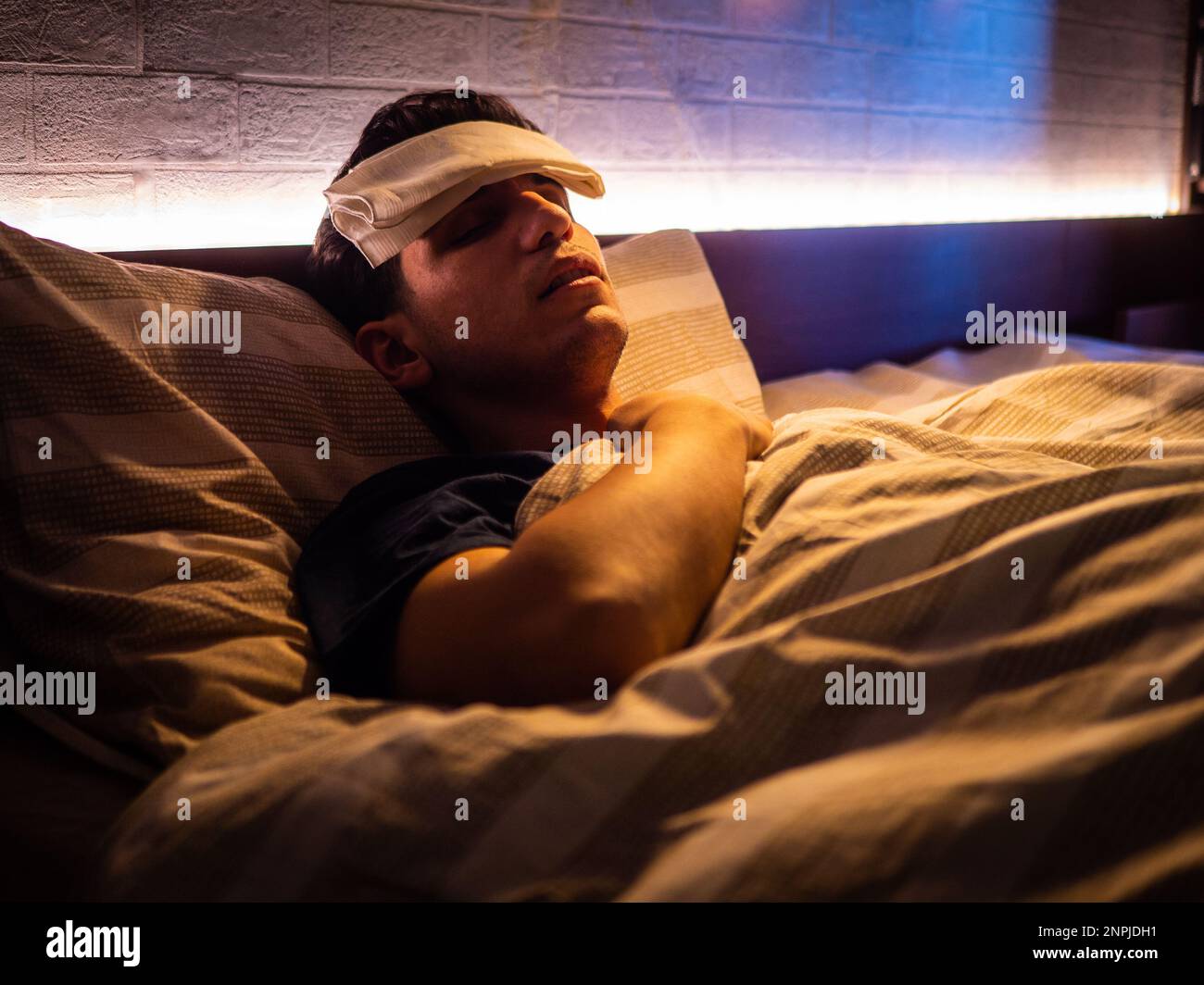 Young handsome sick or unwell man in bed with a flu or fever Stock ...